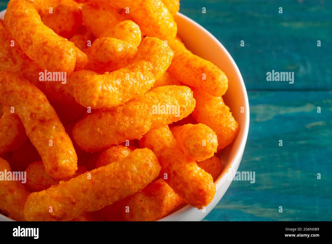 Orange Cheddar Cheese Puffs on a Blue Wood Table Stock Photo - Alamy