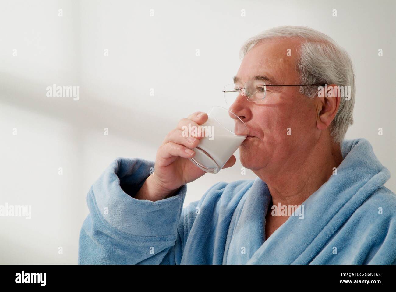 a mature male patient drinking barium sulphate and water from a glass ...