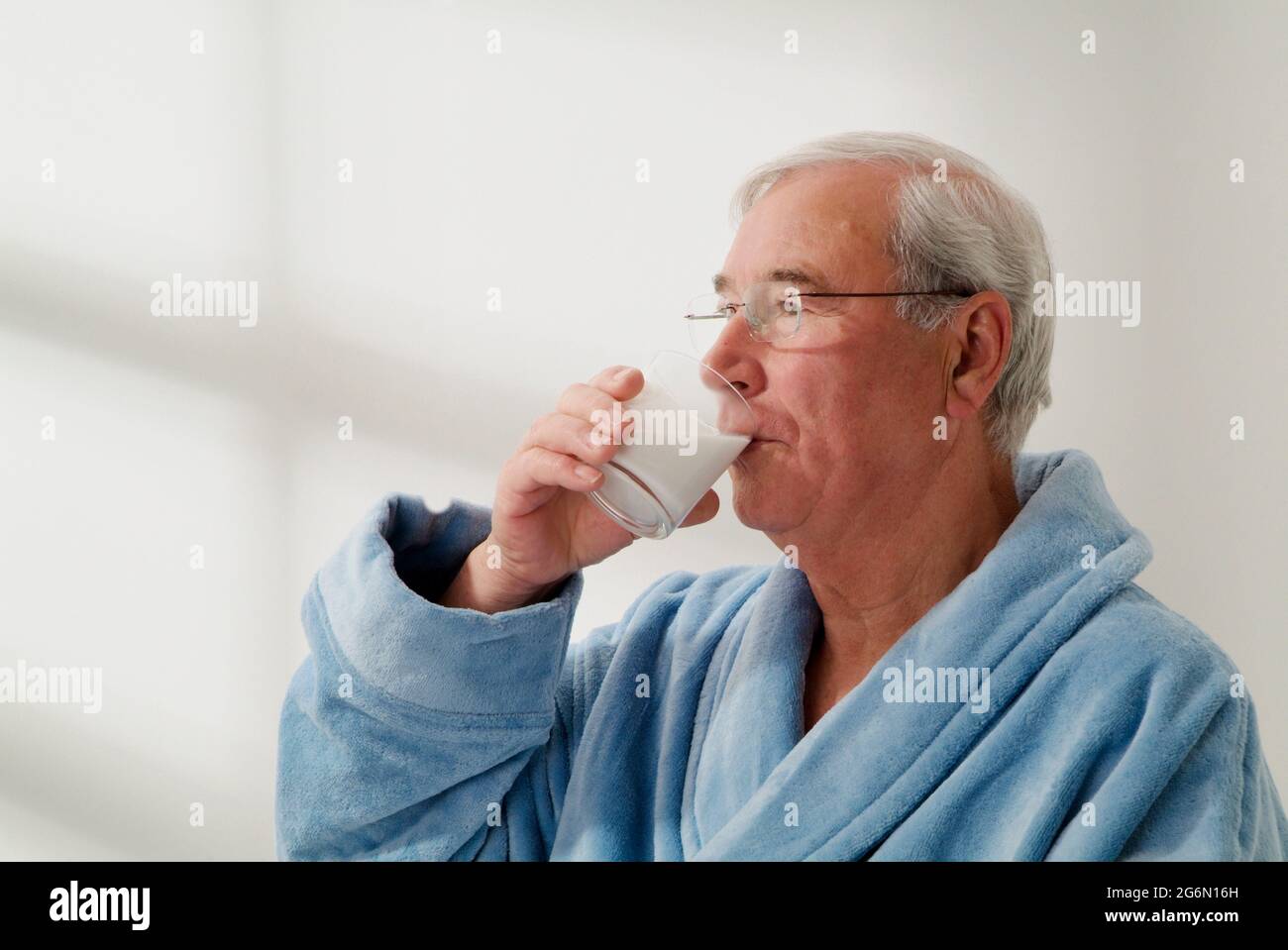 a mature male patient drinking barium sulphate and water from a glass ...