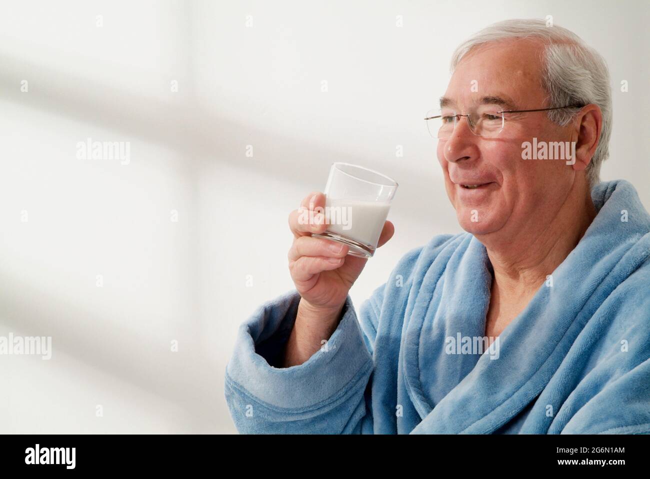 a mature male patient drinking barium sulphate and water from a glass ...