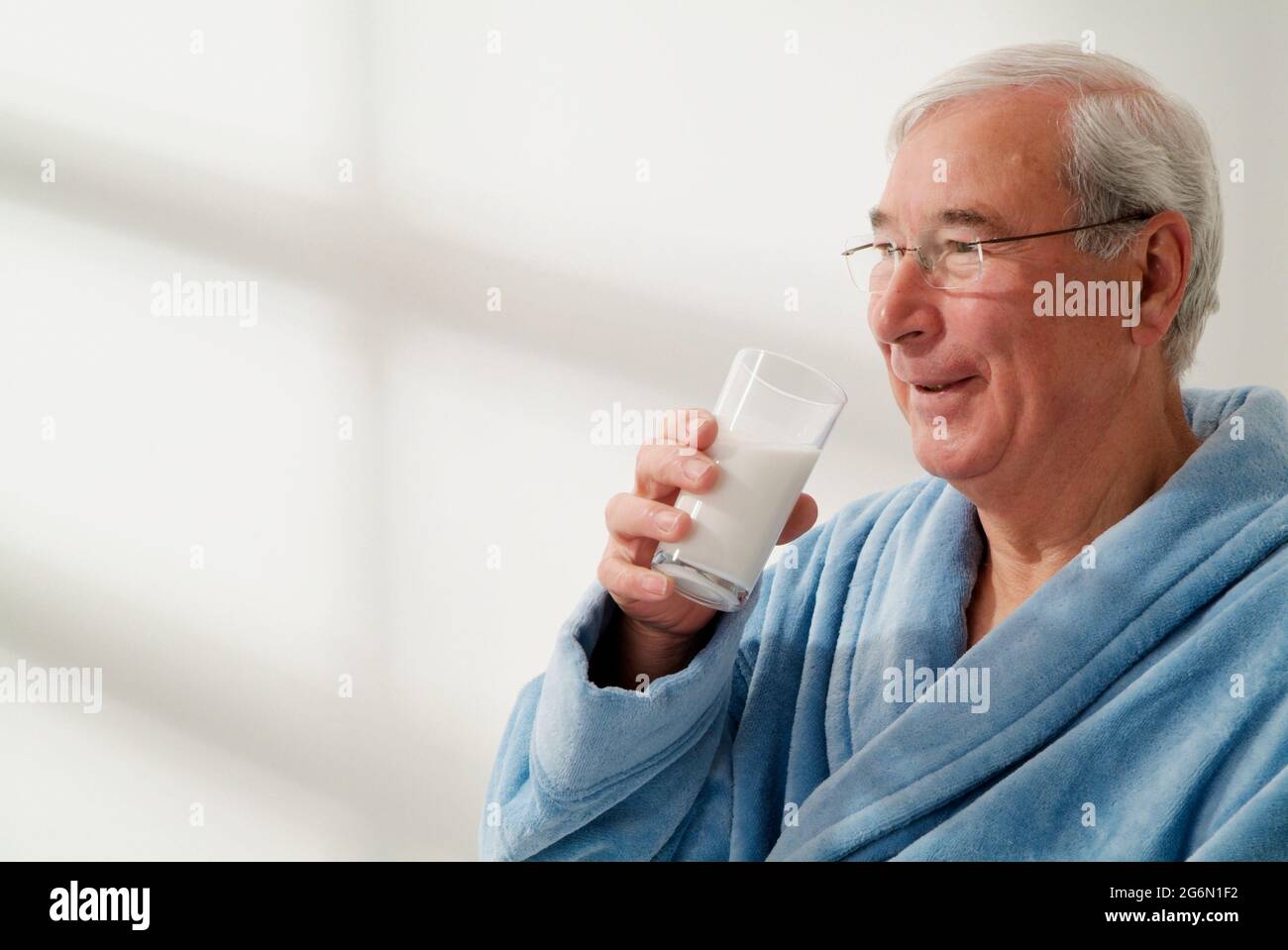 a mature male patient drinking barium sulphate and water from a glass ...