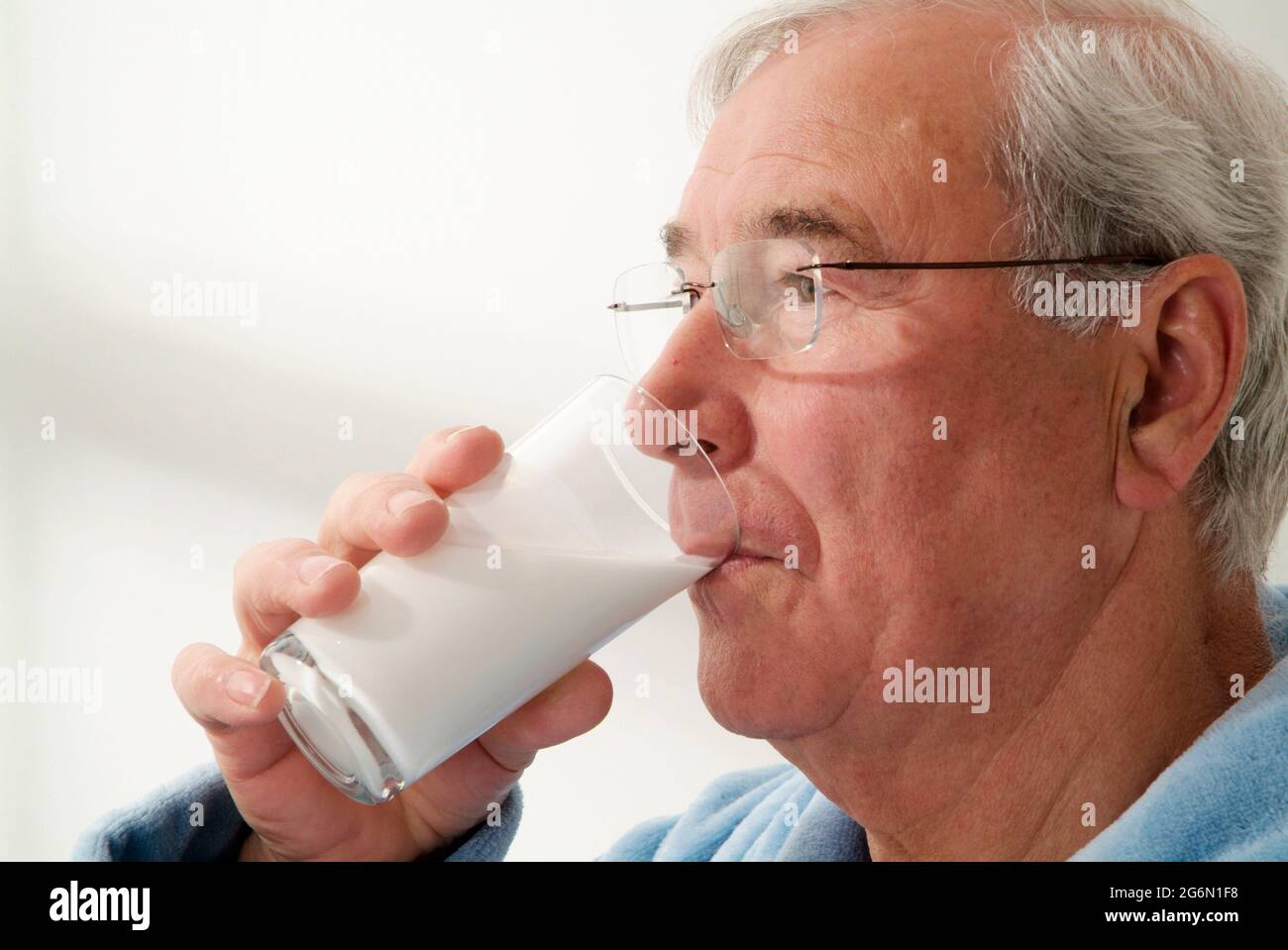 a mature male patient drinking barium sulphate and water from a glass ...
