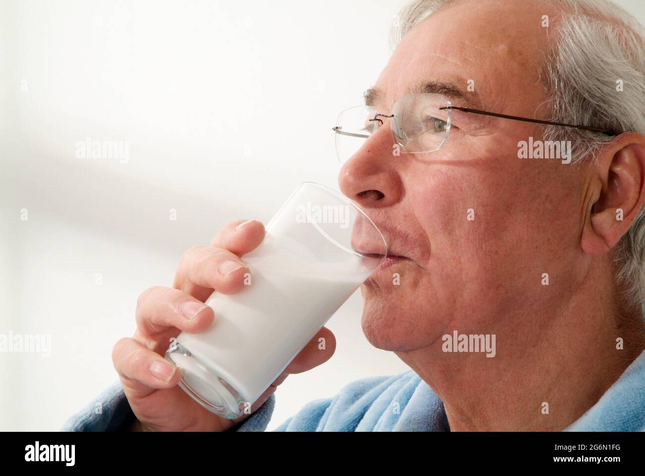 a mature male patient drinking barium sulphate and water from a glass ...