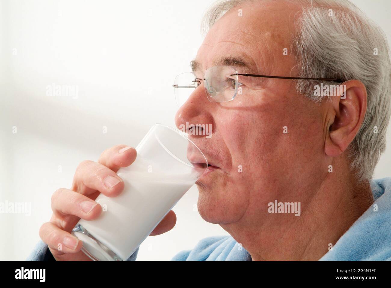 a mature male patient drinking barium sulphate and water from a glass ...