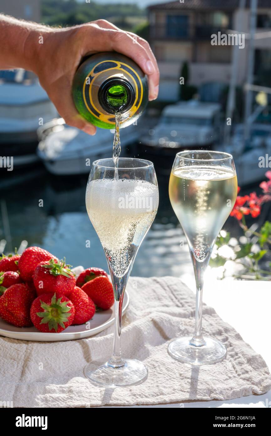 Summer party, pouring of French brut champagne sparkling wine in ...