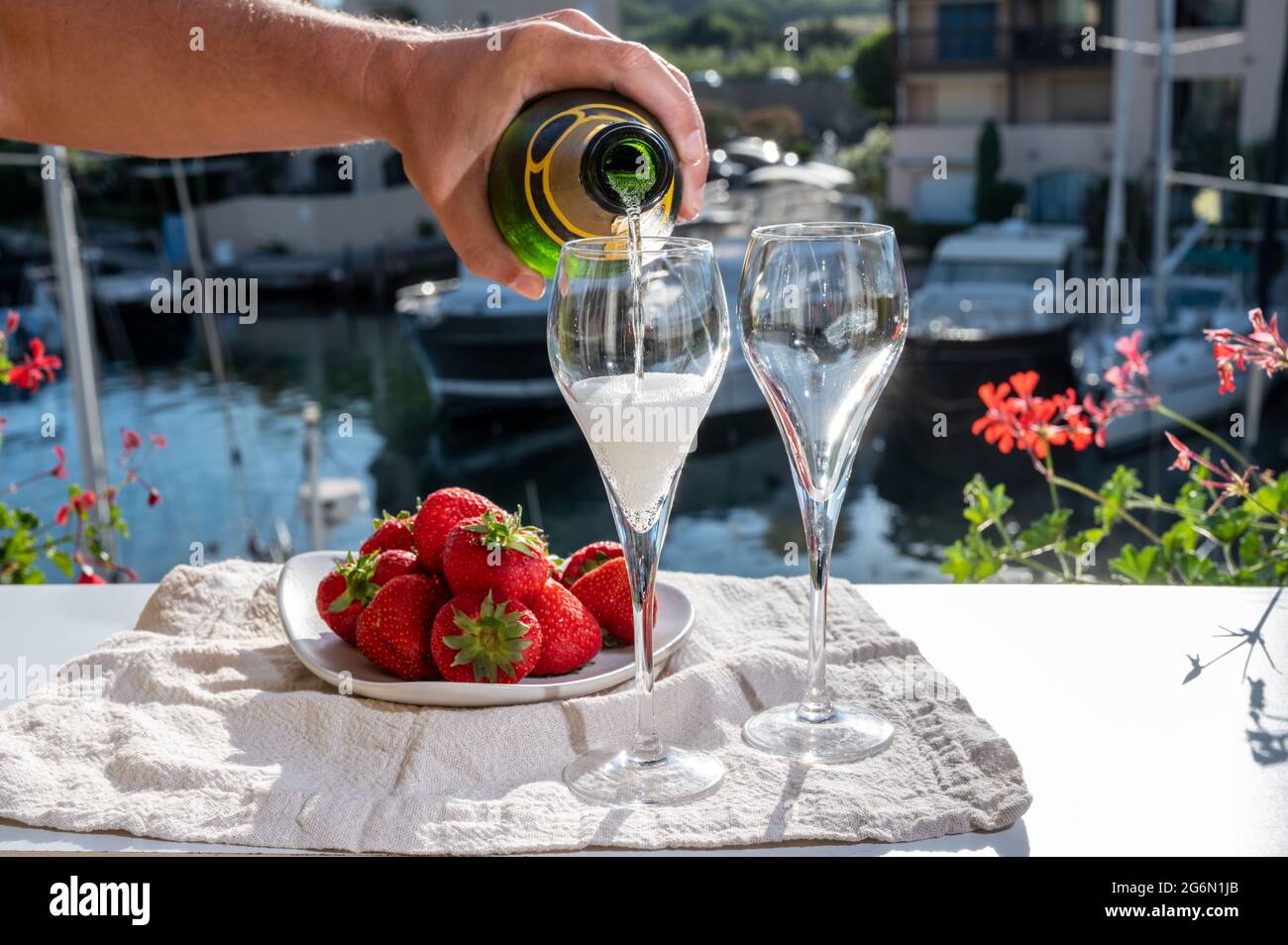 Summer party, pouring of French brut champagne sparkling wine in ...