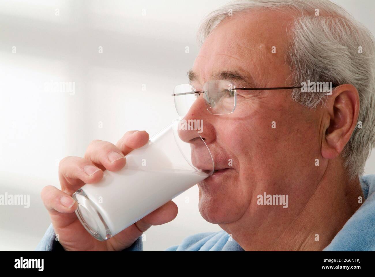 a mature male patient drinking barium sulphate and water from a glass ...