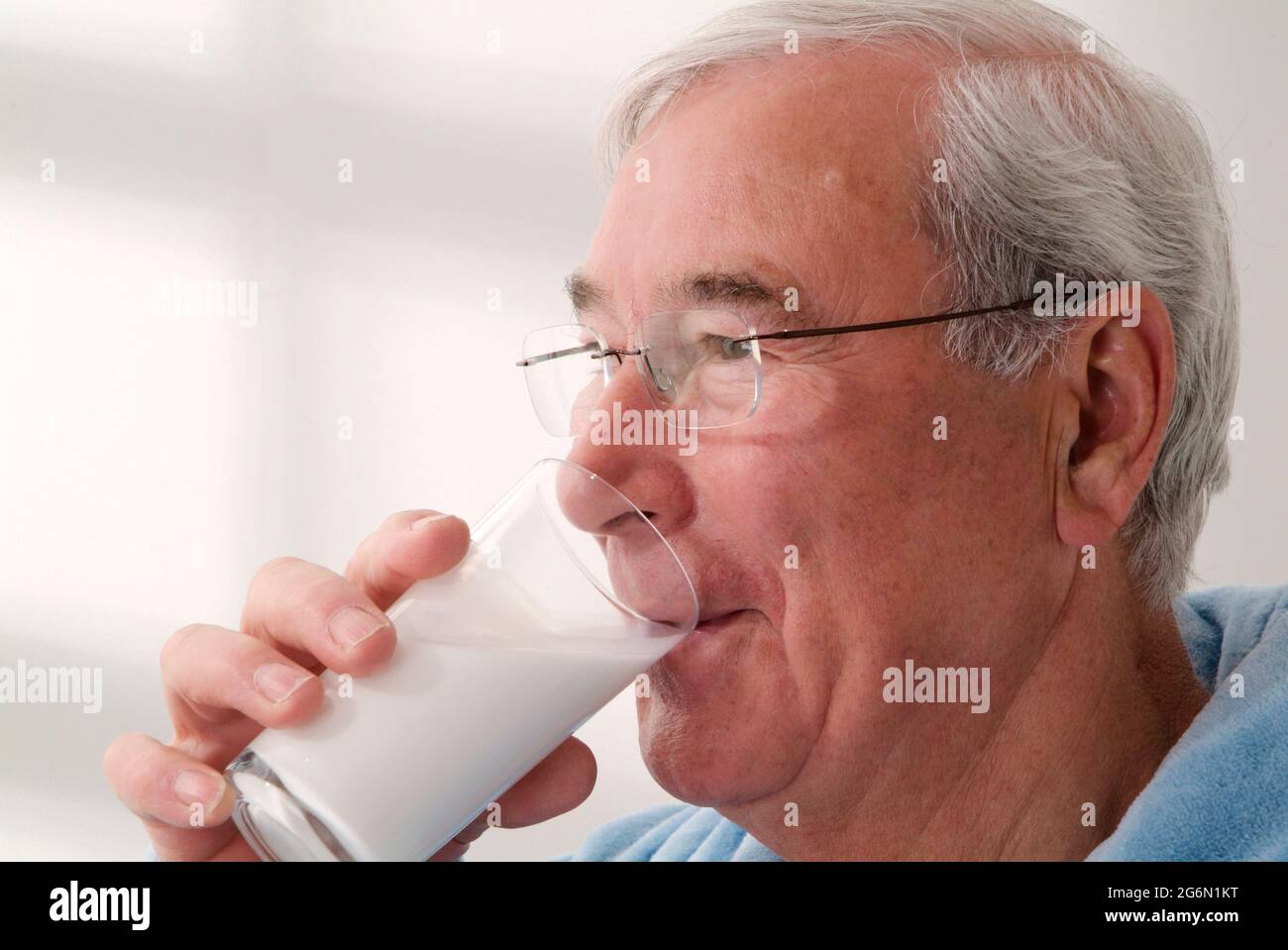 a mature male patient drinking barium sulphate and water from a glass ...