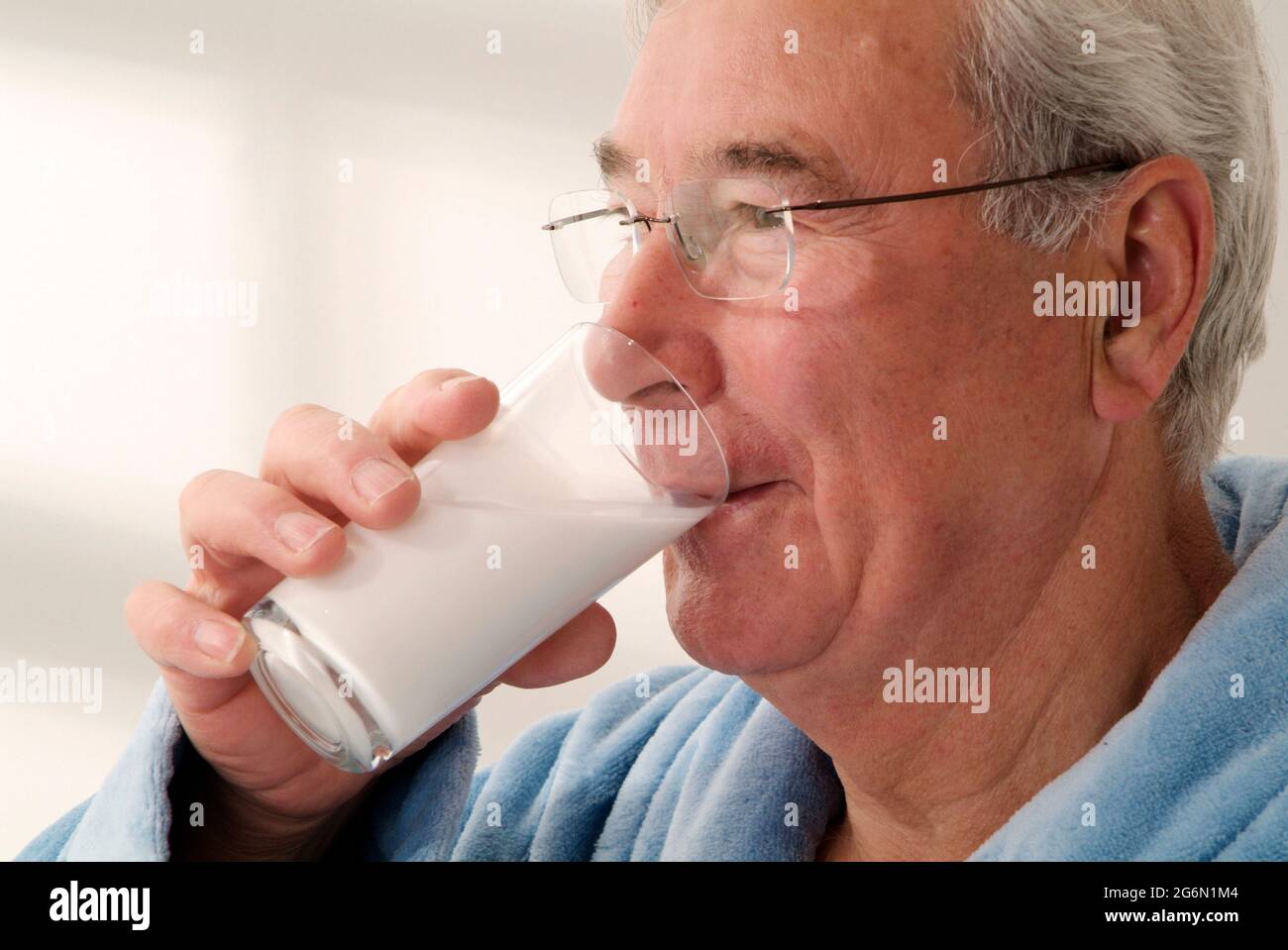 a mature male patient drinking barium sulphate and water from a glass ...