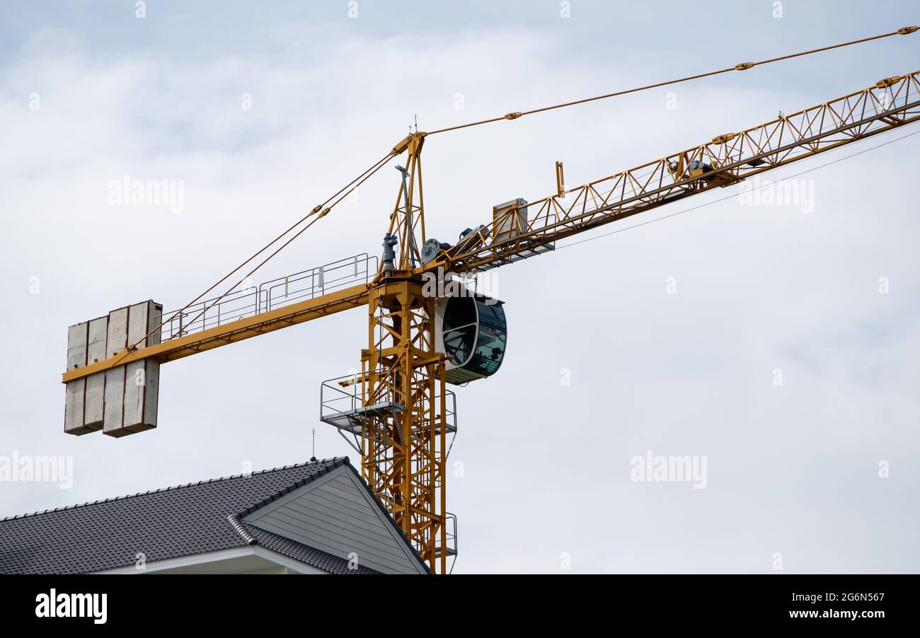 The high tower crane is working over the building in the construction ...