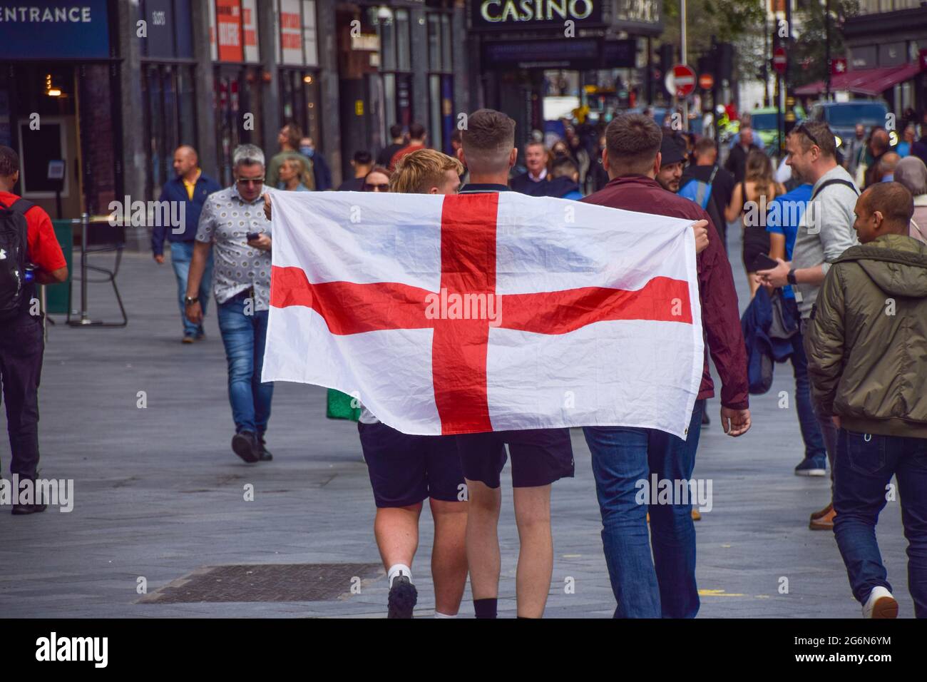 A supporter carries an England flag at Leicester Square ahead of the ...