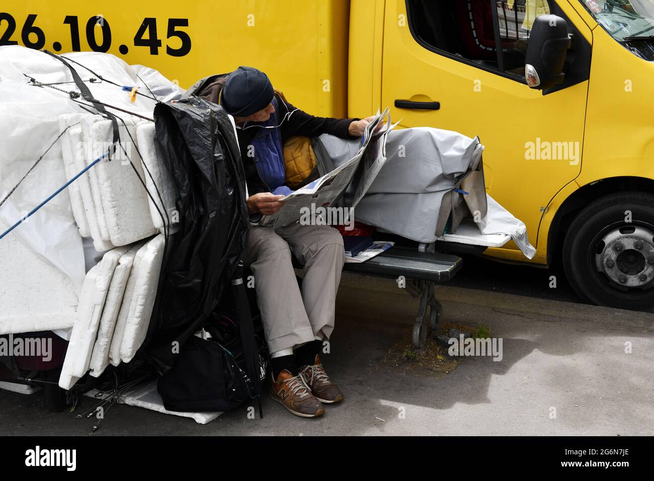 Homeless man reading a newspaper in the street - Paris - France Stock ...