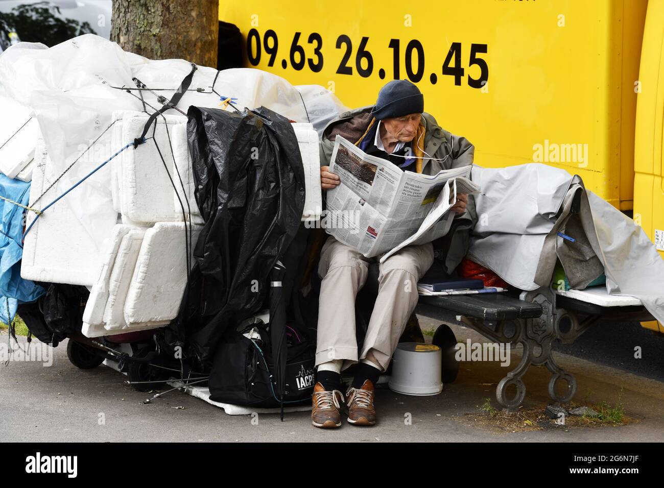Homeless man reading a newspaper in the street - Paris - France Stock ...