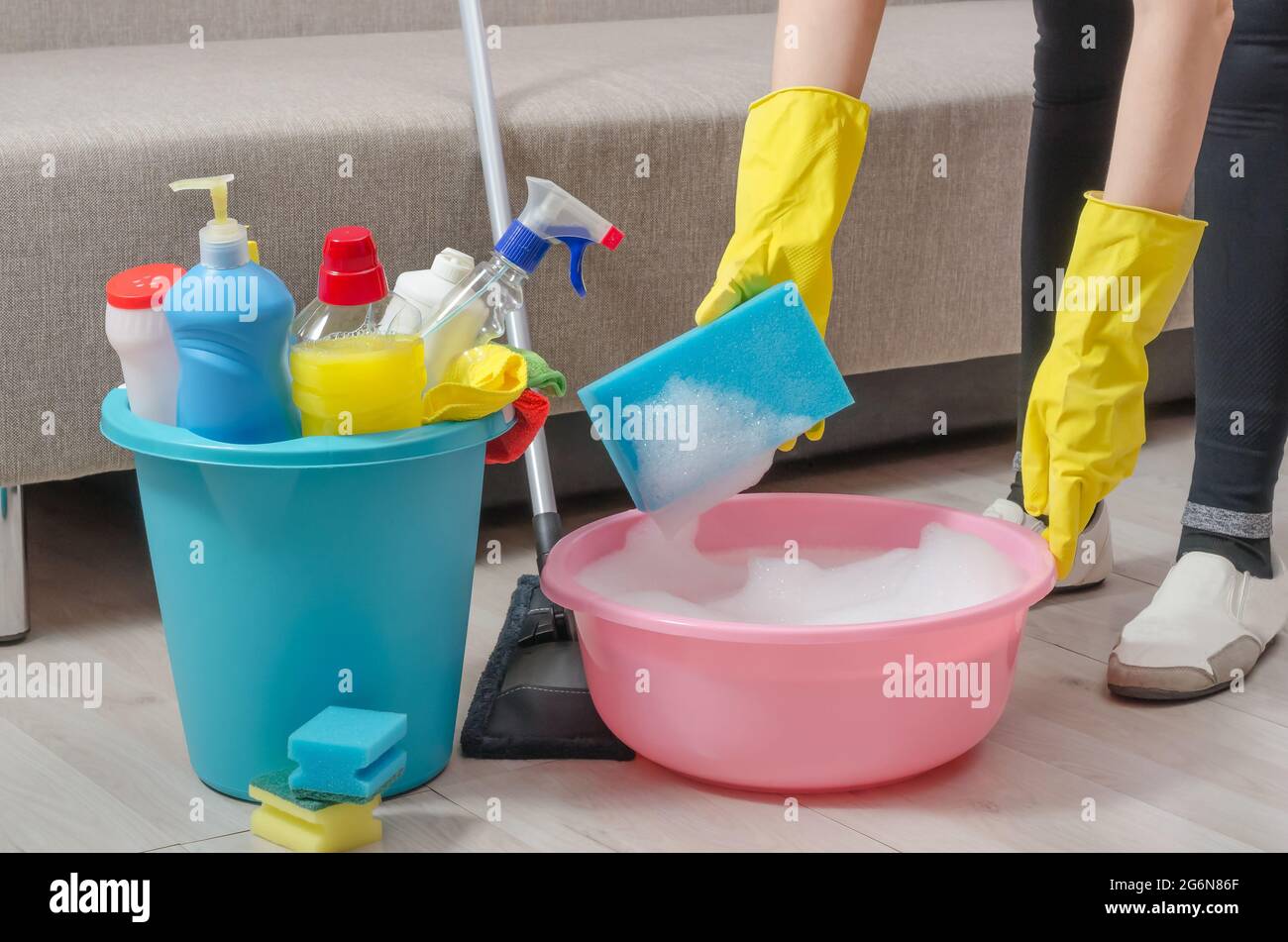 A woman is cleaning the house, in the apartment, holding a sponge over ...