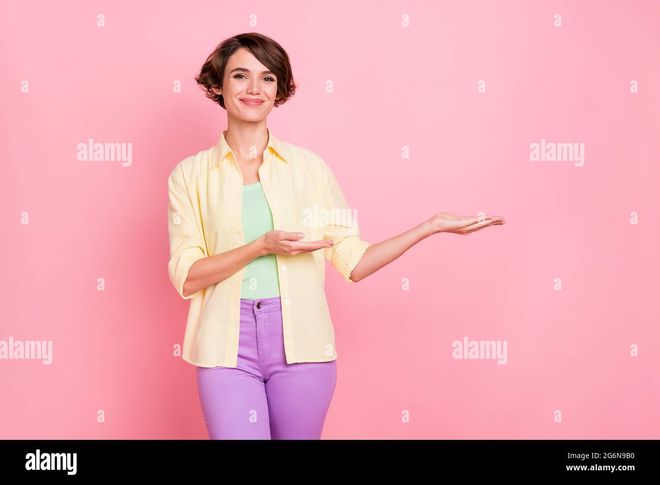 Photo of pretty charming young lady dressed yellow shirt holding arms ...