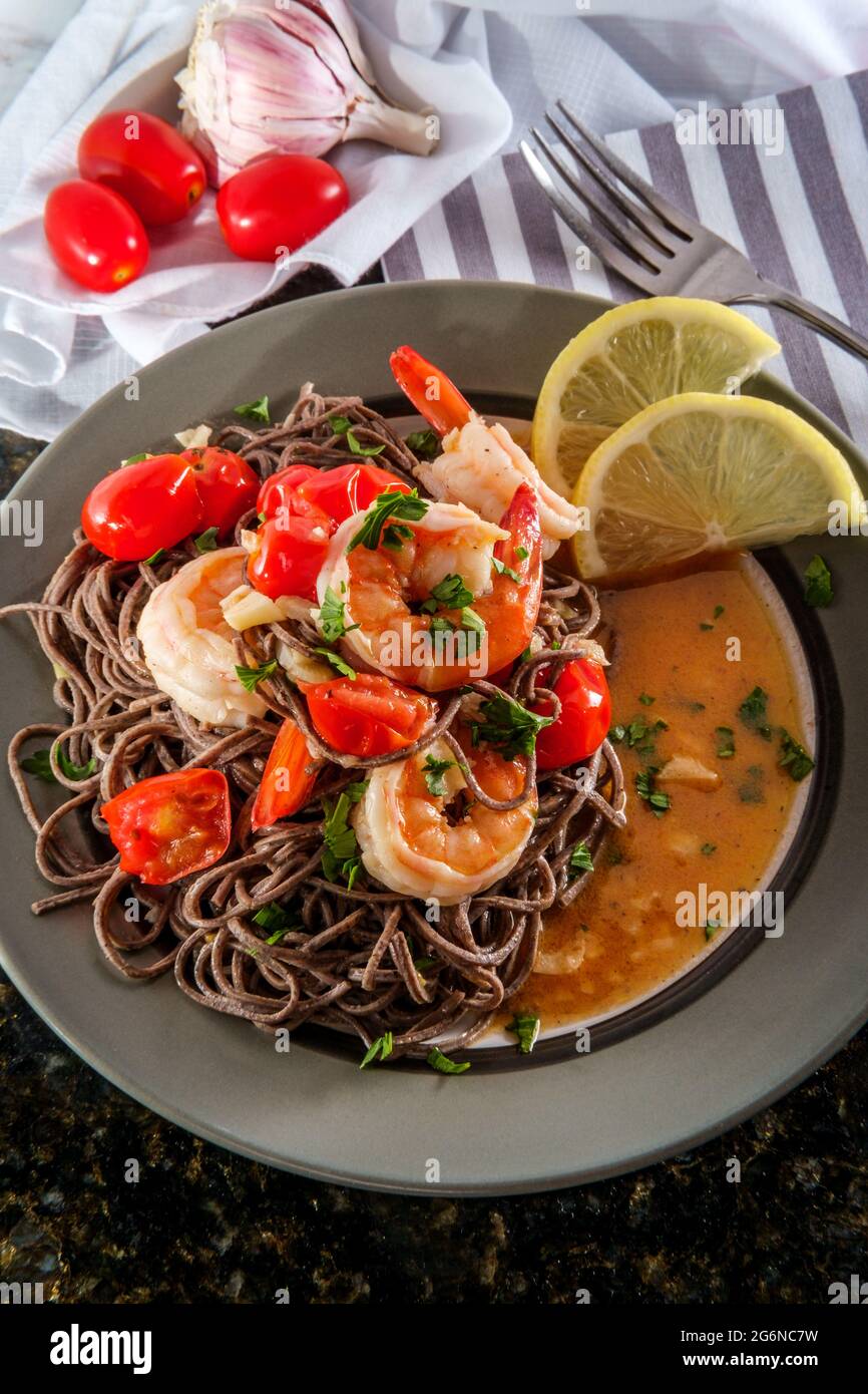Italian shrimp Gamberoni Aglio e Olio with black pasta and cherry ...