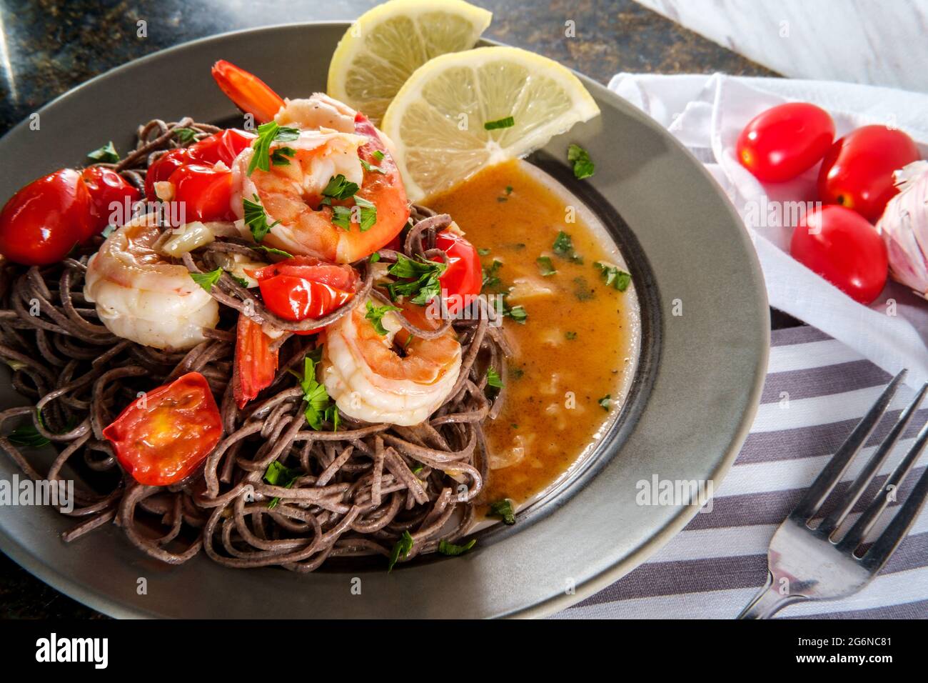 Italian shrimp Gamberoni Aglio e Olio with black pasta and cherry ...