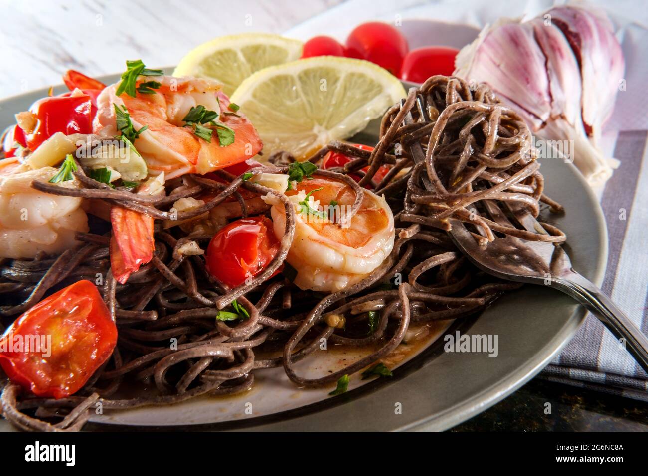 Italian shrimp Gamberoni Aglio e Olio with black pasta and cherry ...