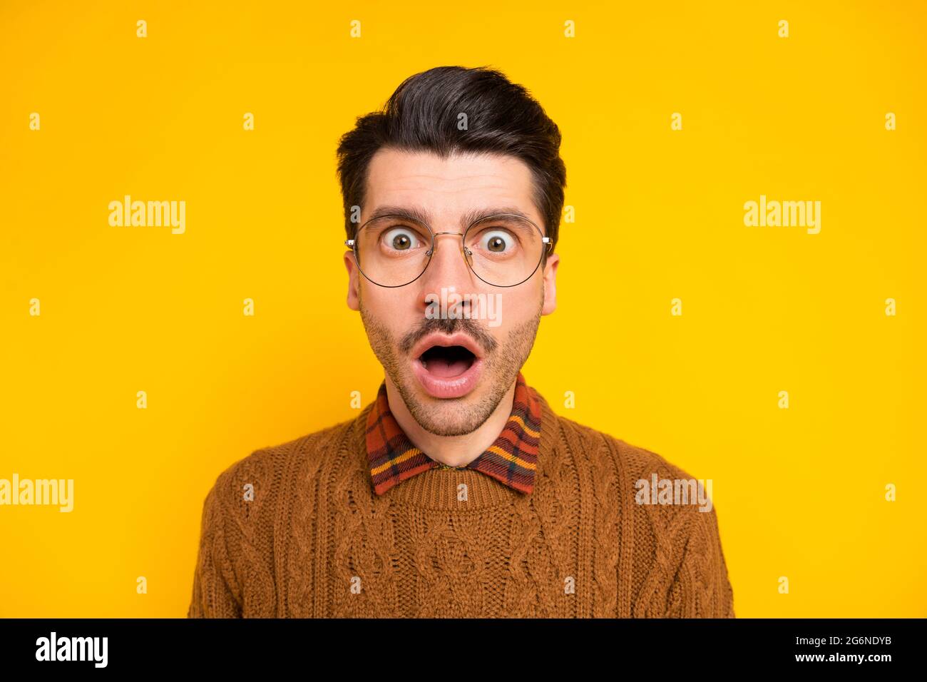 Photo of crazy shocked young guy open mouth staring camera wear brown ...