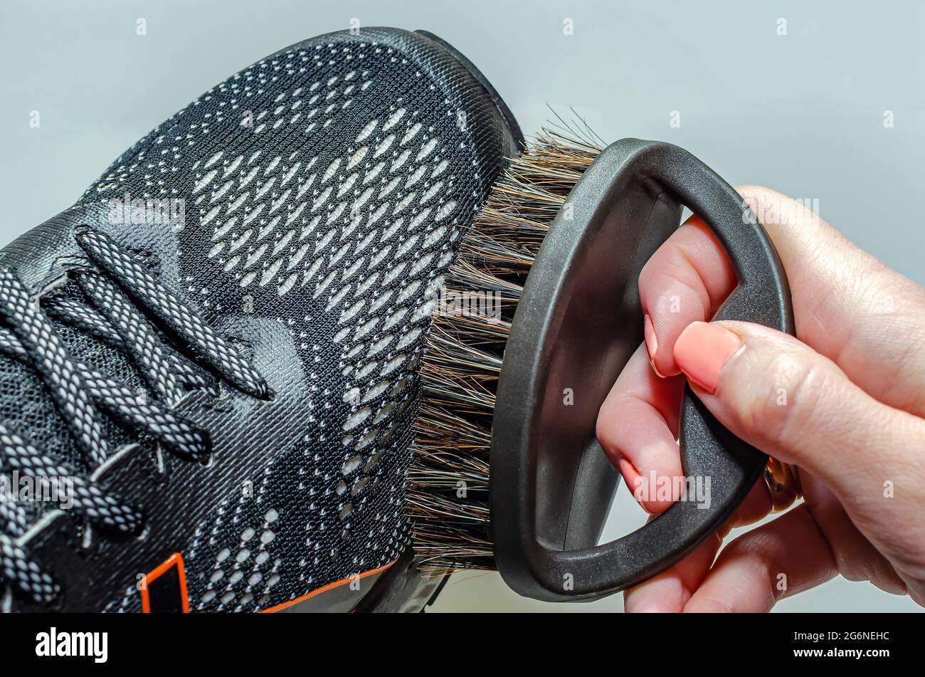 cleans sports shoes, woman cleans shoes with a brush. Cleaning dirty ...