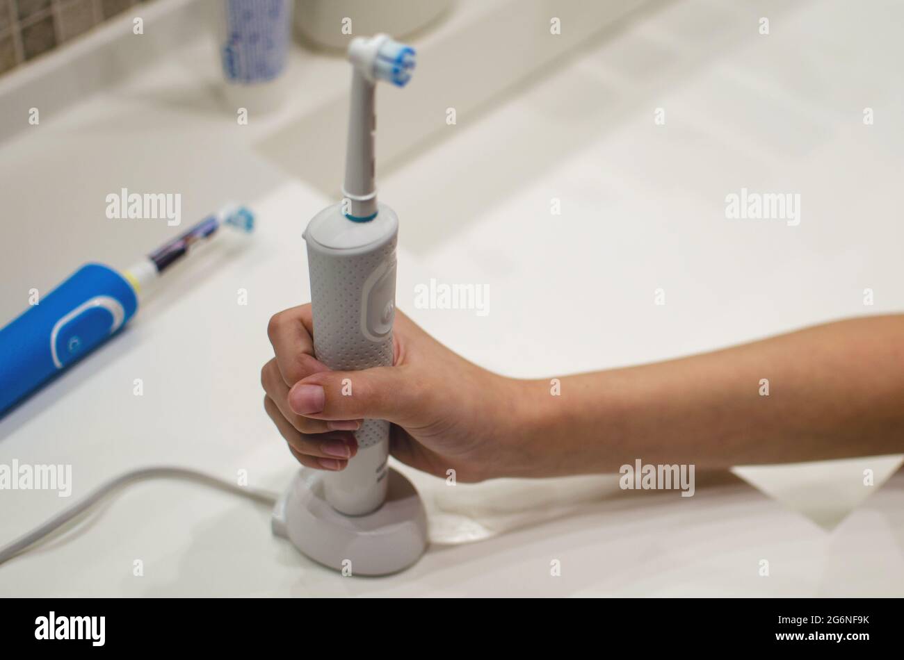 Hand with an electric toothbrush on a light background, charger Stock ...