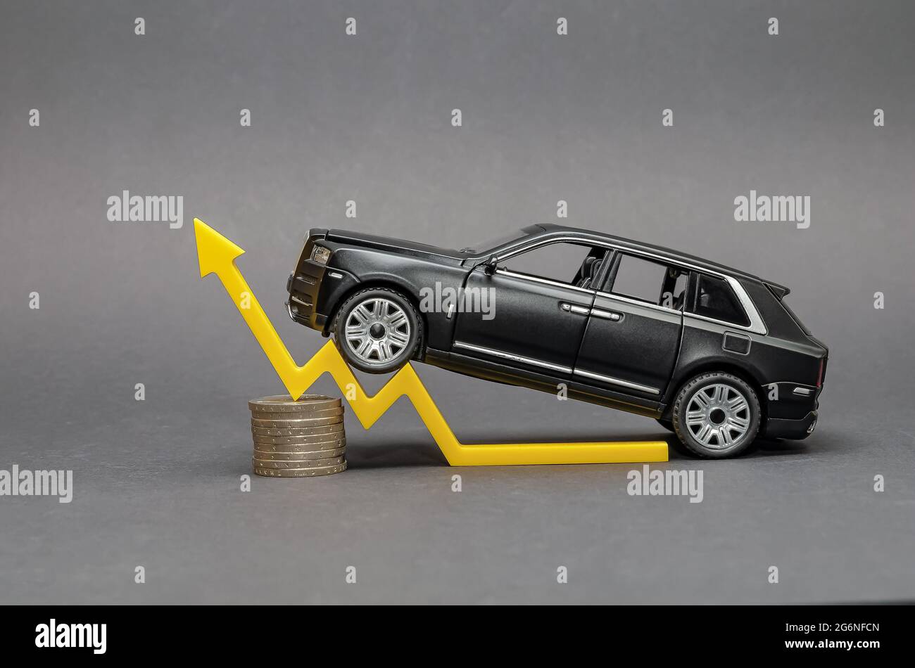 Rising car prices. On a black background, there is a model car with a ...