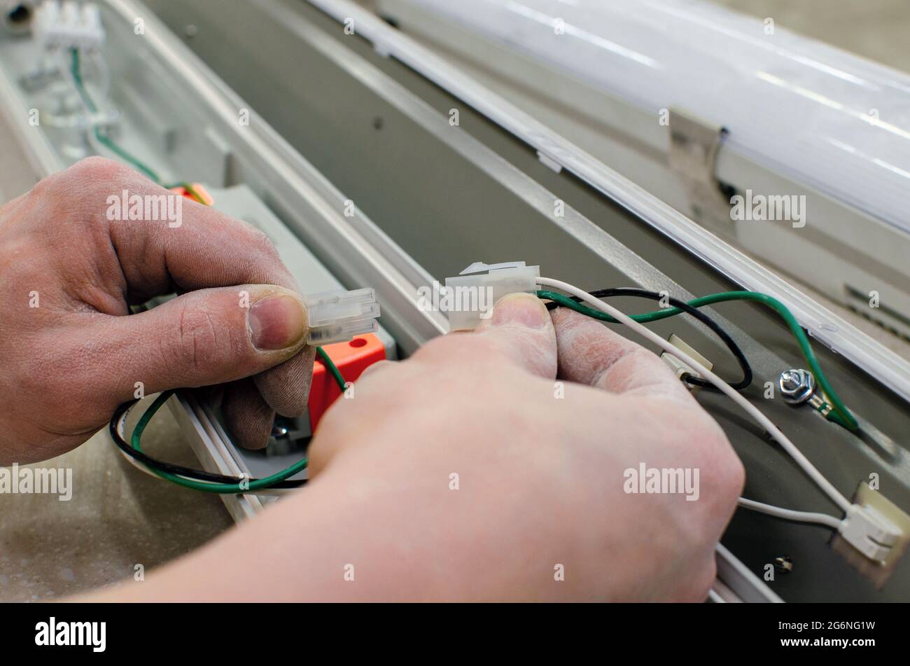 electrician installs ceiling fluorescent lamps. Repair and maintenance ...