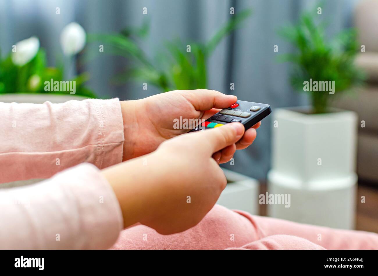 Little girl holding tv remote control at home Stock Photo - Alamy
