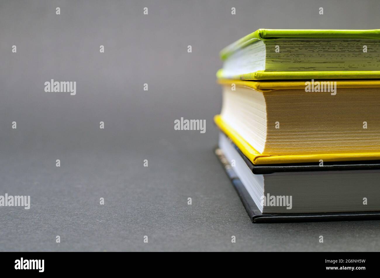A simple composition of many hardback books on a black background. Back ...