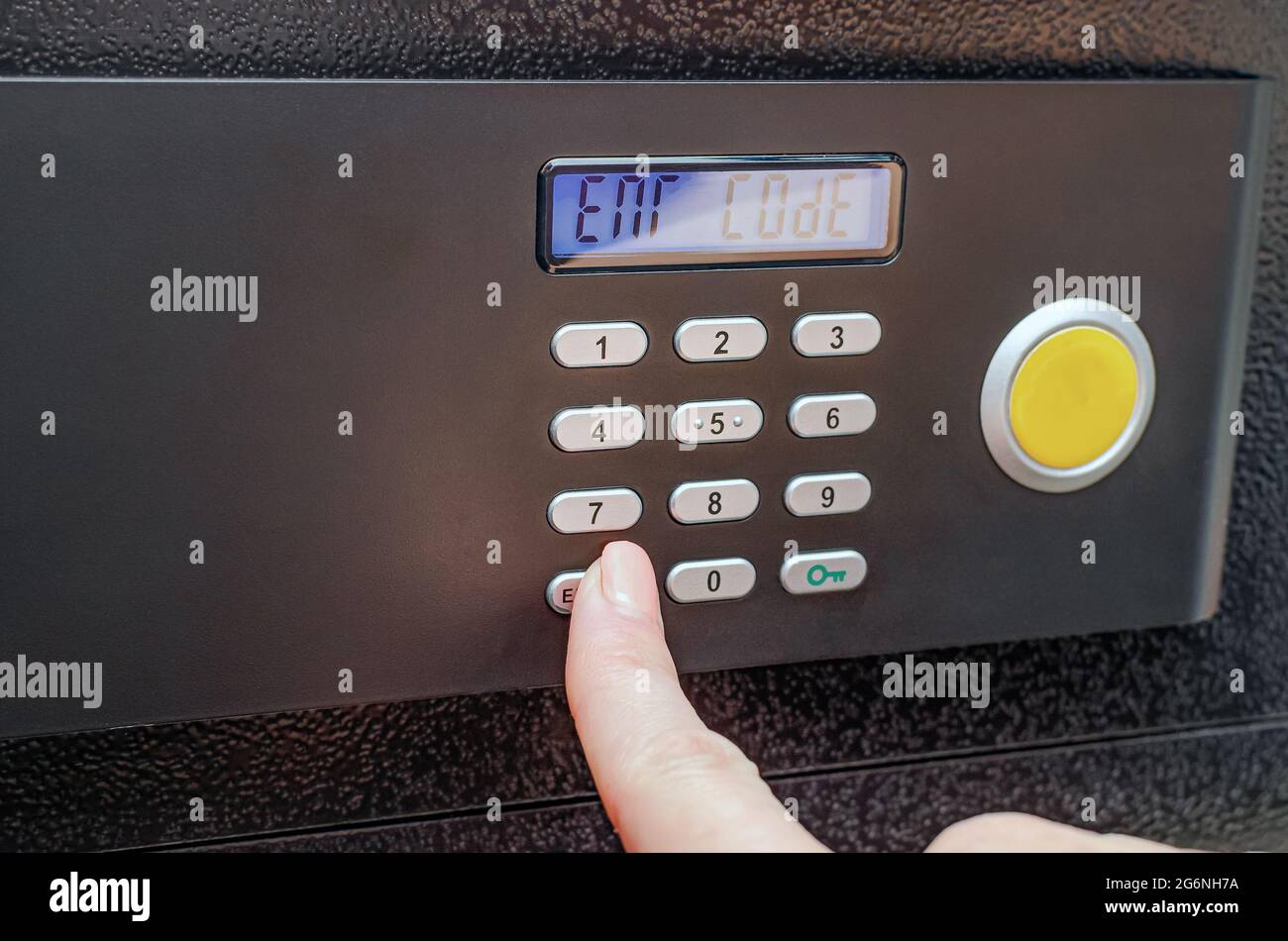 Woman hand opens or close a safe hidden in the wardrobe at the hotel ...