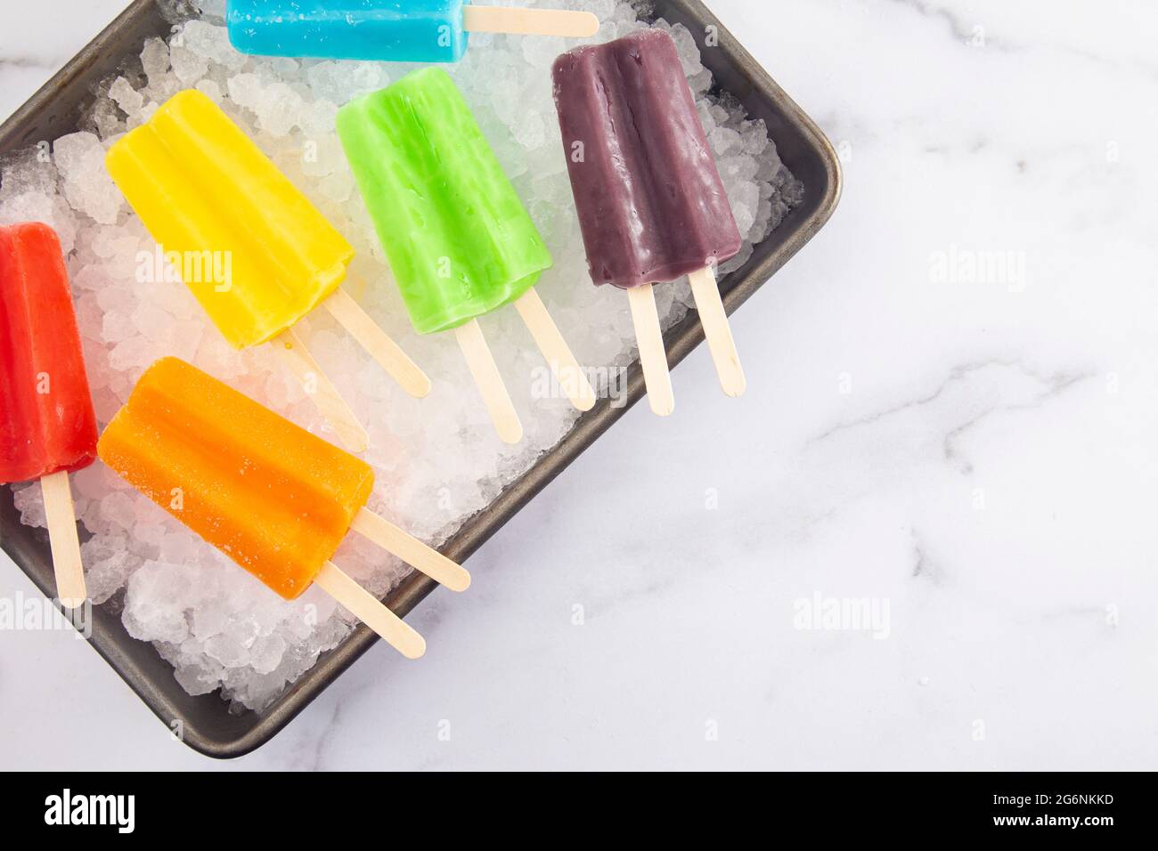 Rainbow Two Stick Popsicles in a a Box of Ice Stock Photo - Alamy