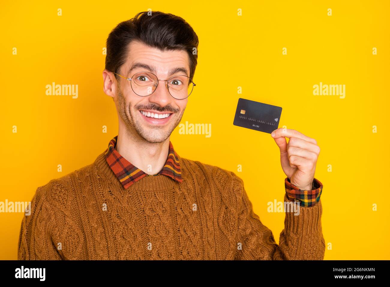 Photo of promoter guy hold credit card beaming smile wear eyewear brown ...