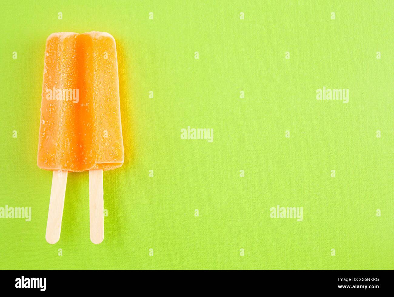 Orange Popsicle on a Bright Green Background Stock Photo - Alamy