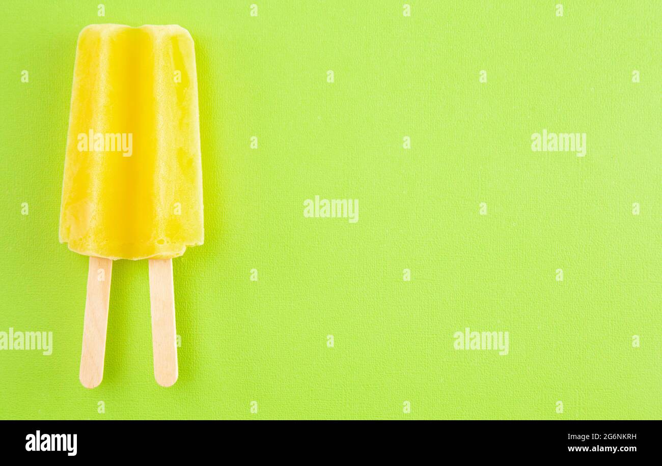 Yellow Popsicle on a Bright Green Background Stock Photo - Alamy