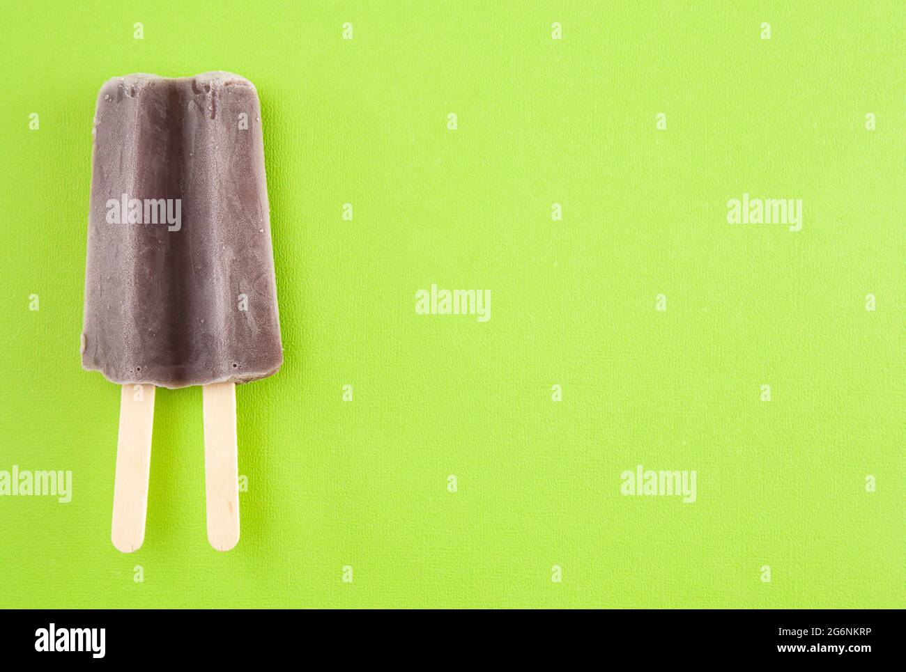 Purple Popsicle on a Bright Green Background Stock Photo - Alamy