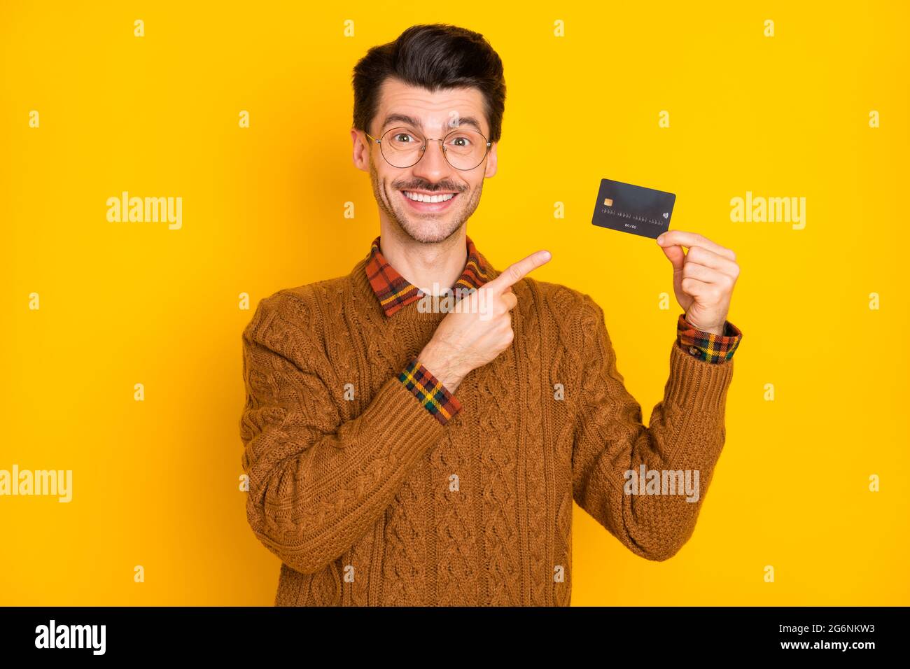 Portrait of positive guy indicate finger debit card toothy smile wear ...