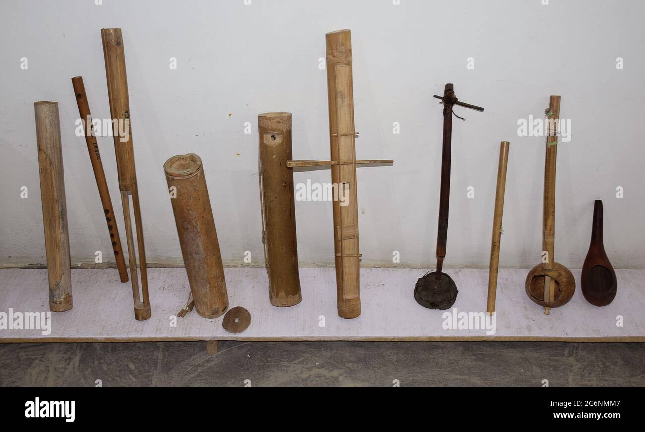 Various traditional music instruments made of wood and bamboo are kept ...