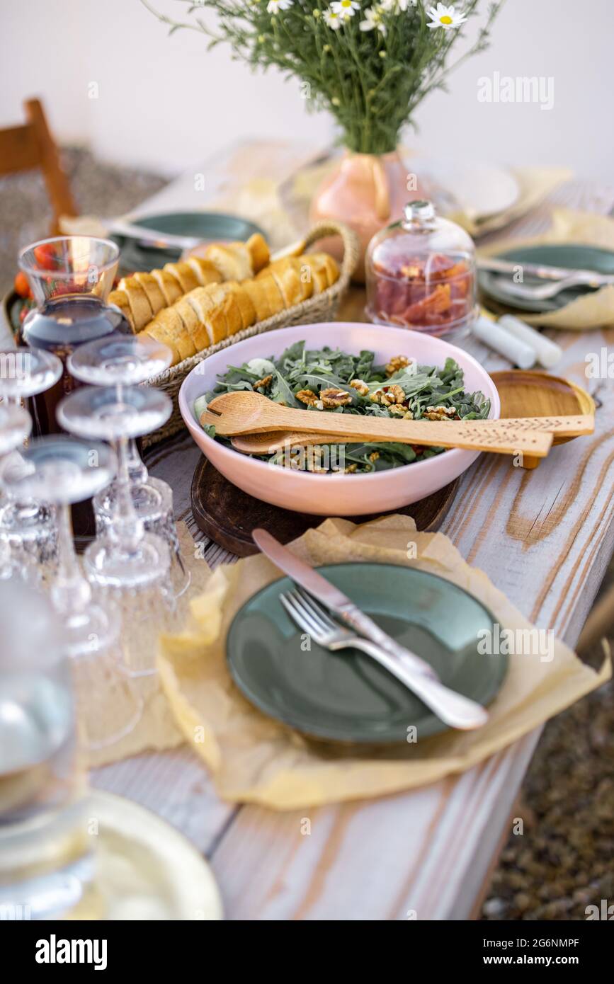 Beautifully served wooden table with food and dishes in natural boho ...