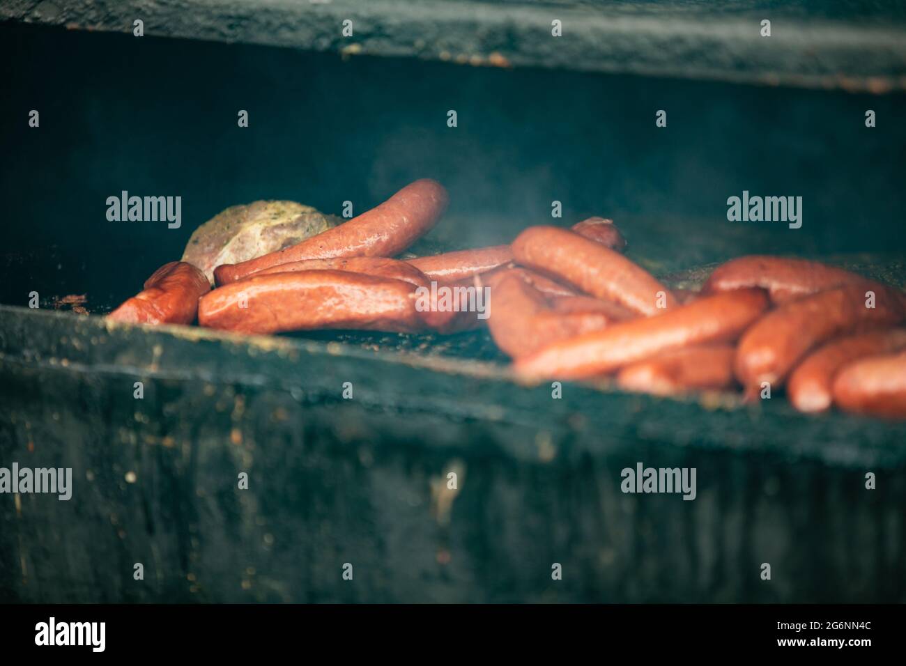 Polish Sausages being cooked and smoked on an outdoor grill at a ...