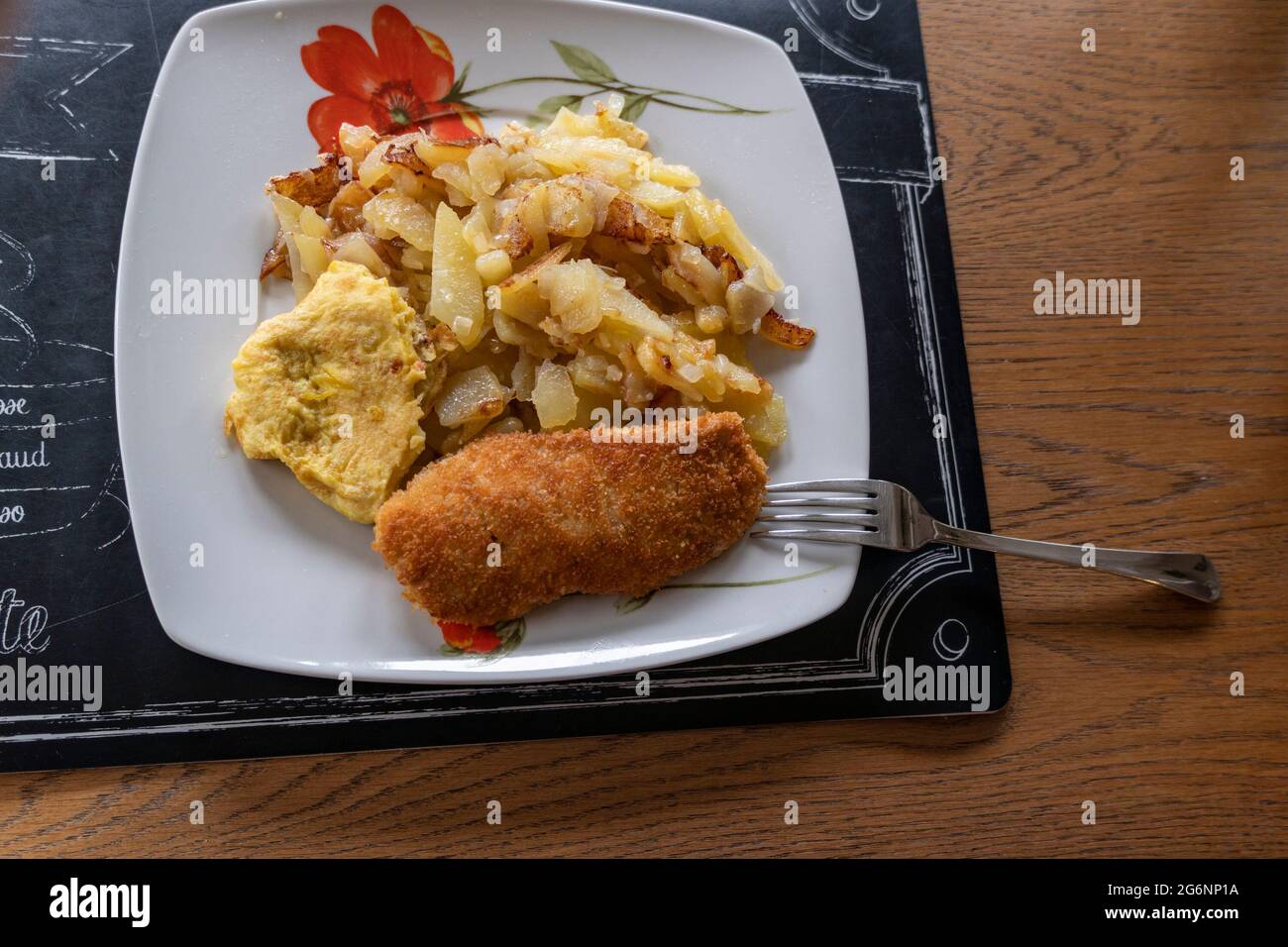 Simple peasant food, fried potatoes and a piece of meat with an egg ...