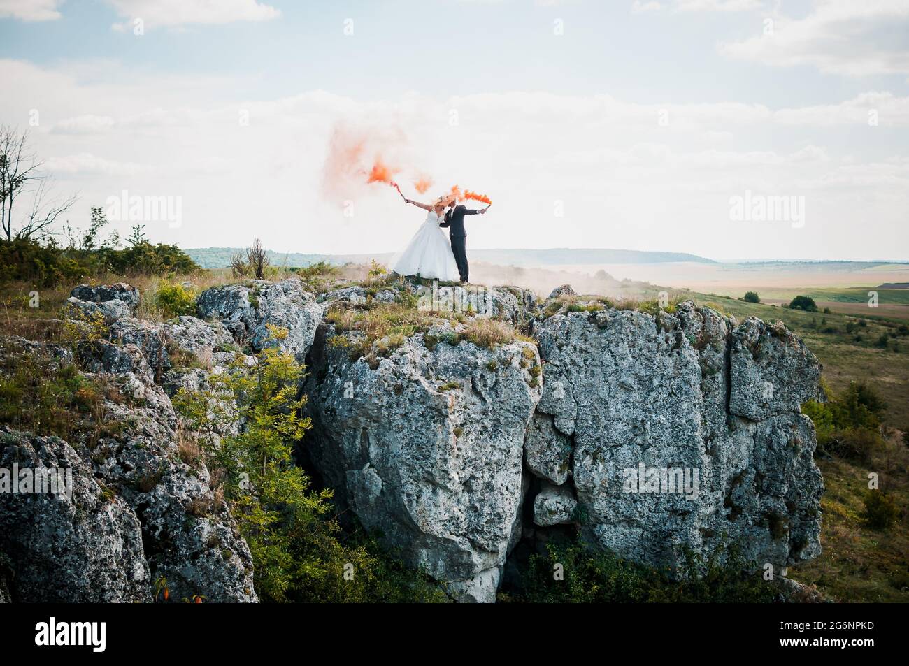 Newlyweds on the background of rocks and hold colorful smoke in their ...