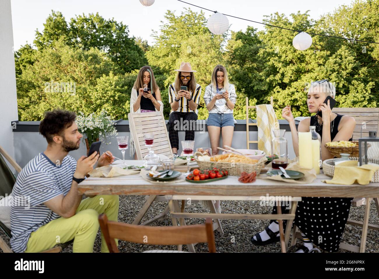 People spending time together, sitting separately in smart phones at ...