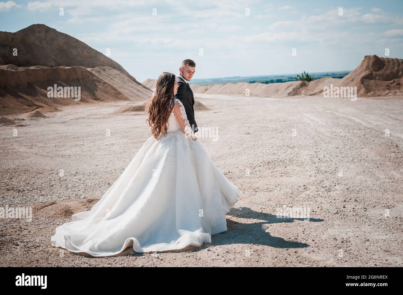Newlyweds walk in a sandy quarry Stock Photo - Alamy