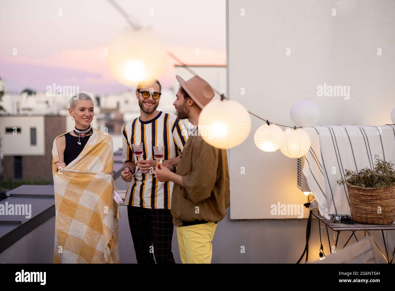 Friends have fun on a rooftop party at dusk Stock Photo - Alamy