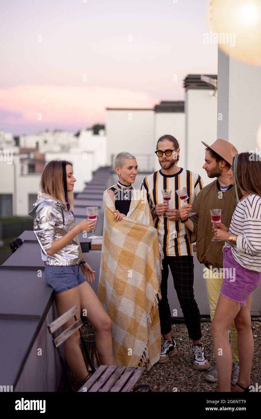 Friends have fun on a rooftop party at dusk Stock Photo - Alamy