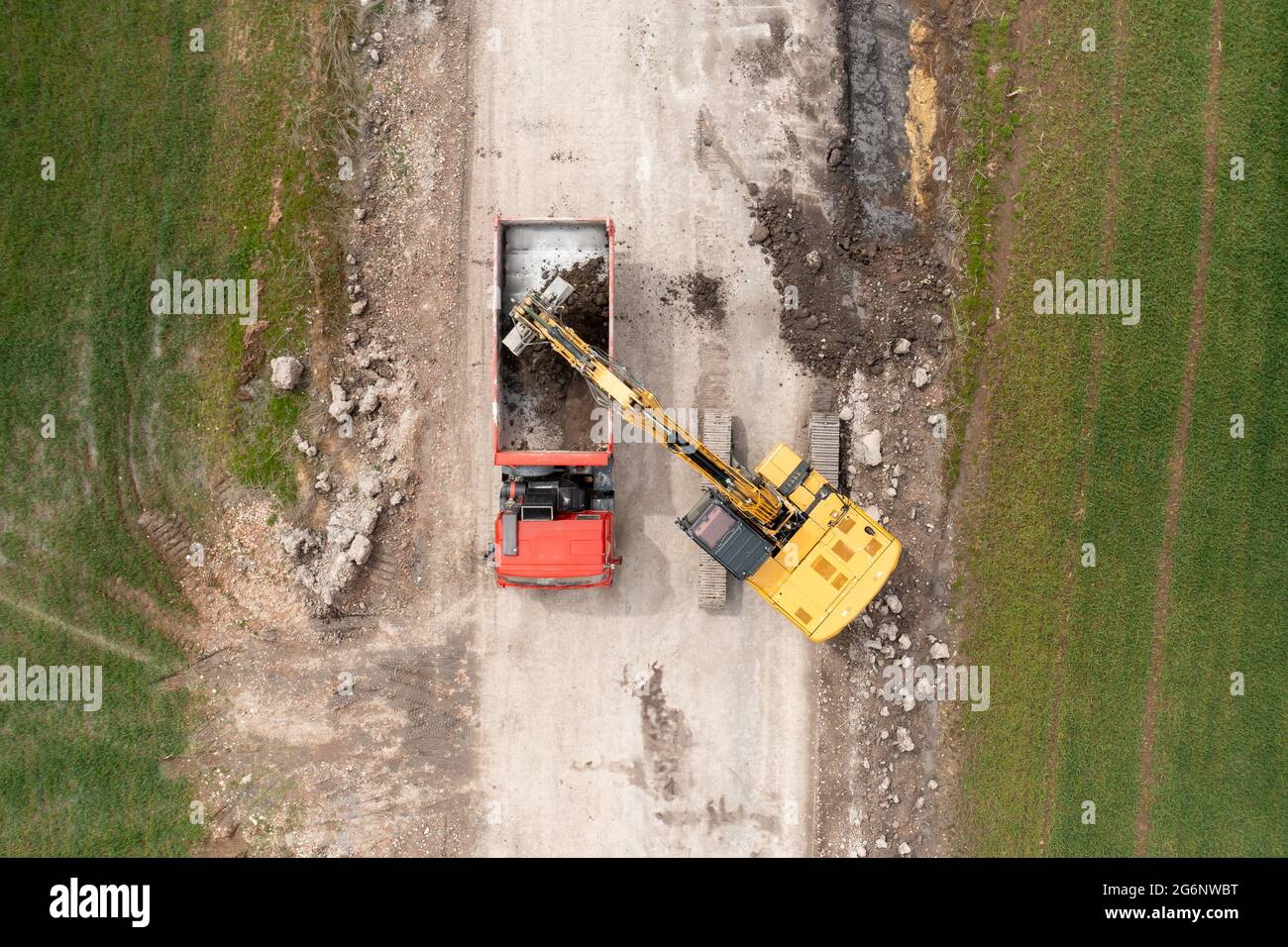 Excavator digging ground near the field and loading to the truck Stock ...
