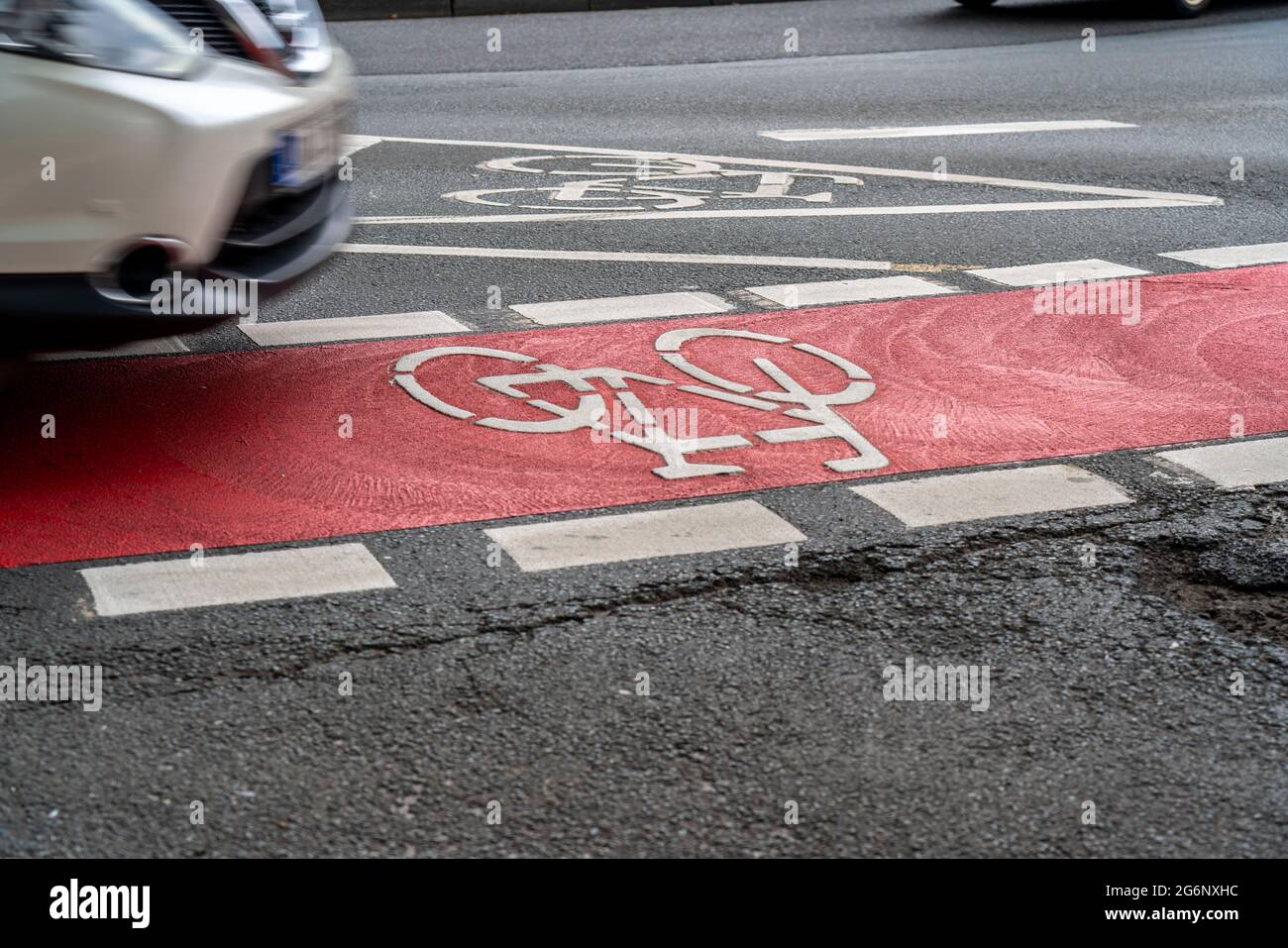 Red cycle lane marking in an inner-city roundabout, to make drivers ...