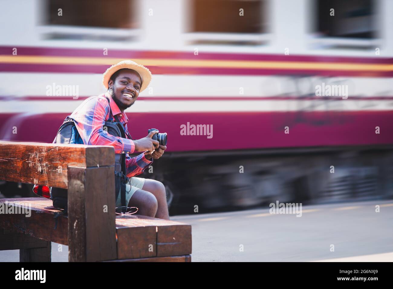 African male traveler waiting for the train on railway station ...