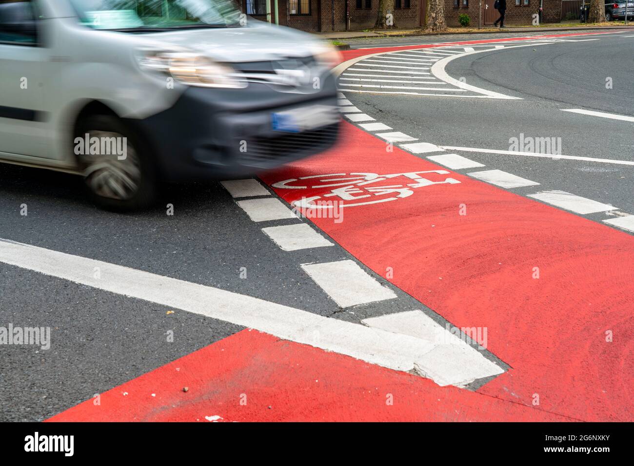 Red cycle lane marking in an inner-city roundabout, to make drivers ...