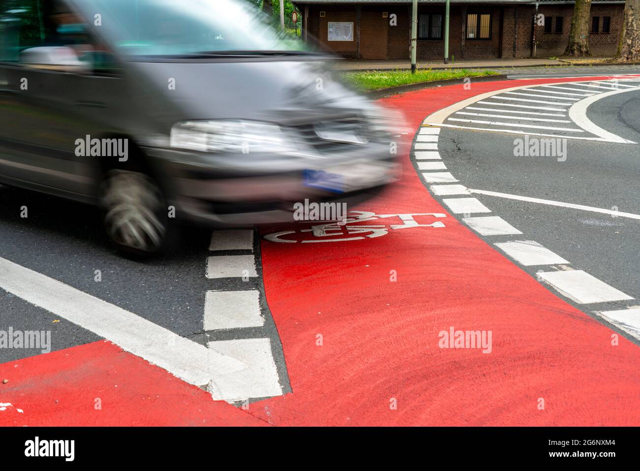 Red cycle lane marking in an inner-city roundabout, to make drivers ...